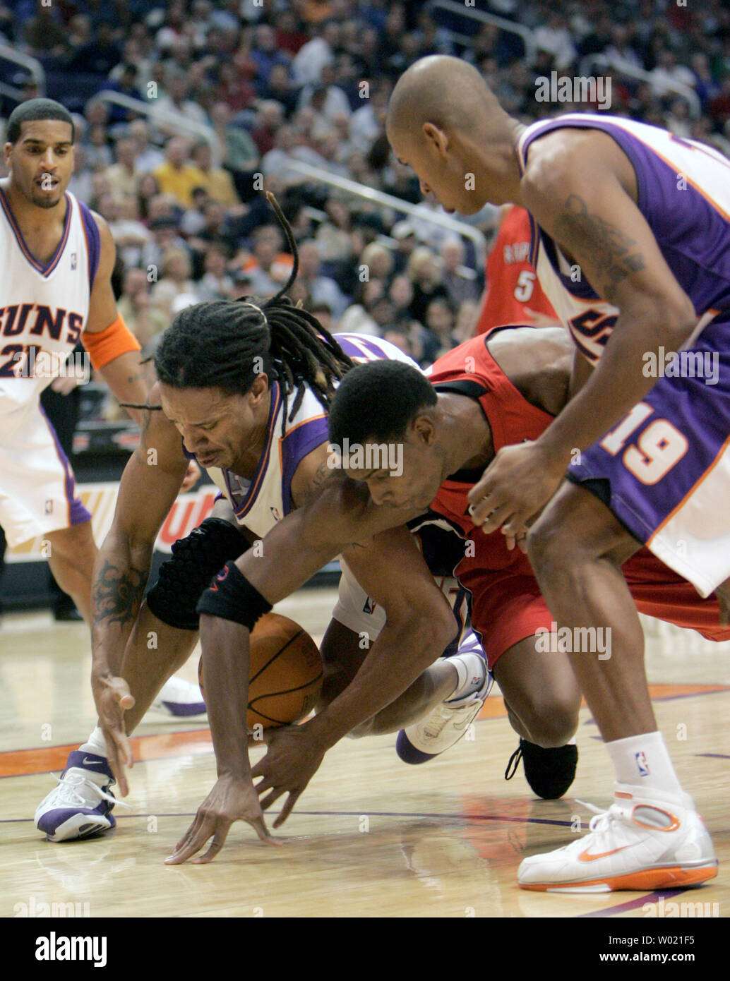 Phoenix Sun Brian Grant and Toronto Raptor Chris Bosh wrestle for a ...