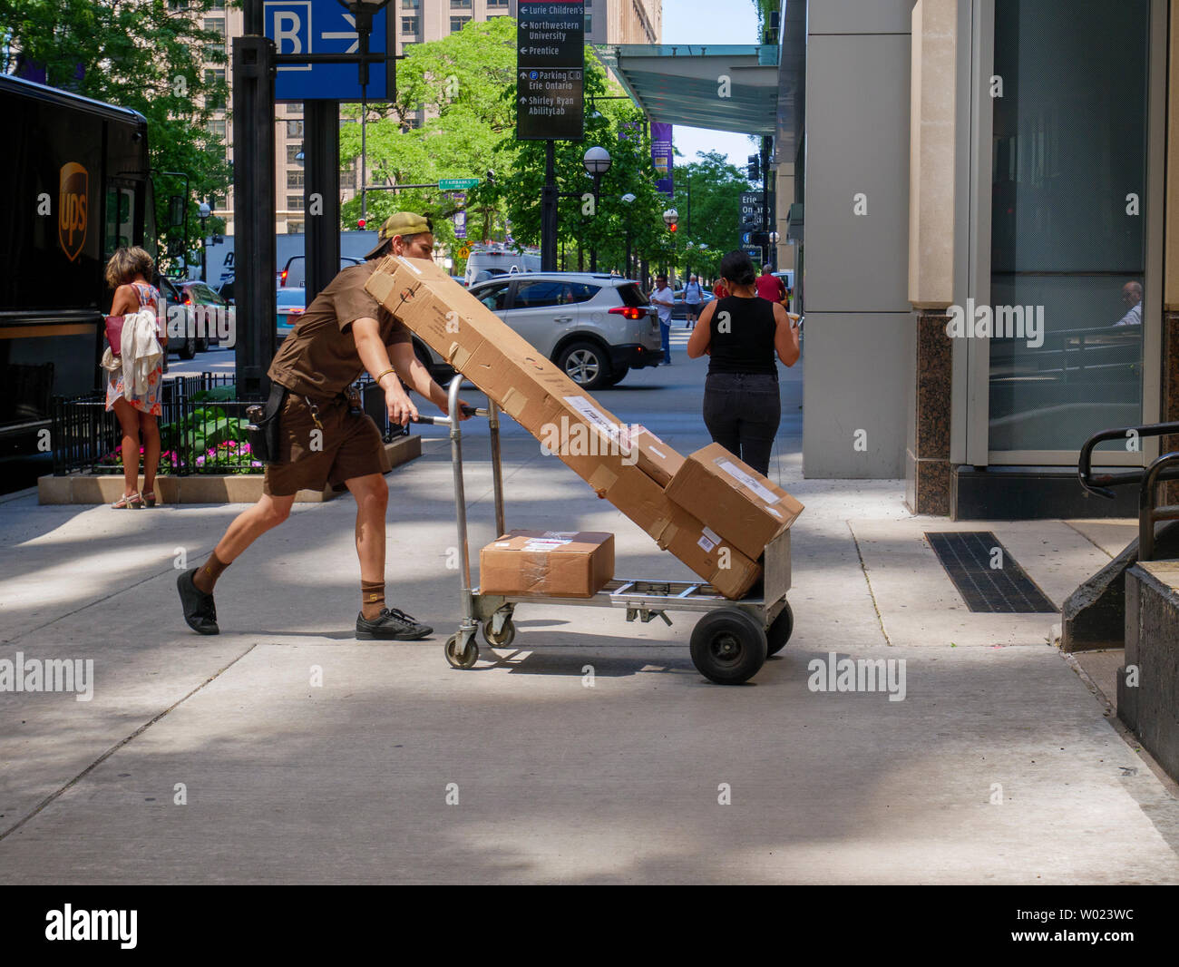 Delivery driver using cart Stock Photo - Alamy