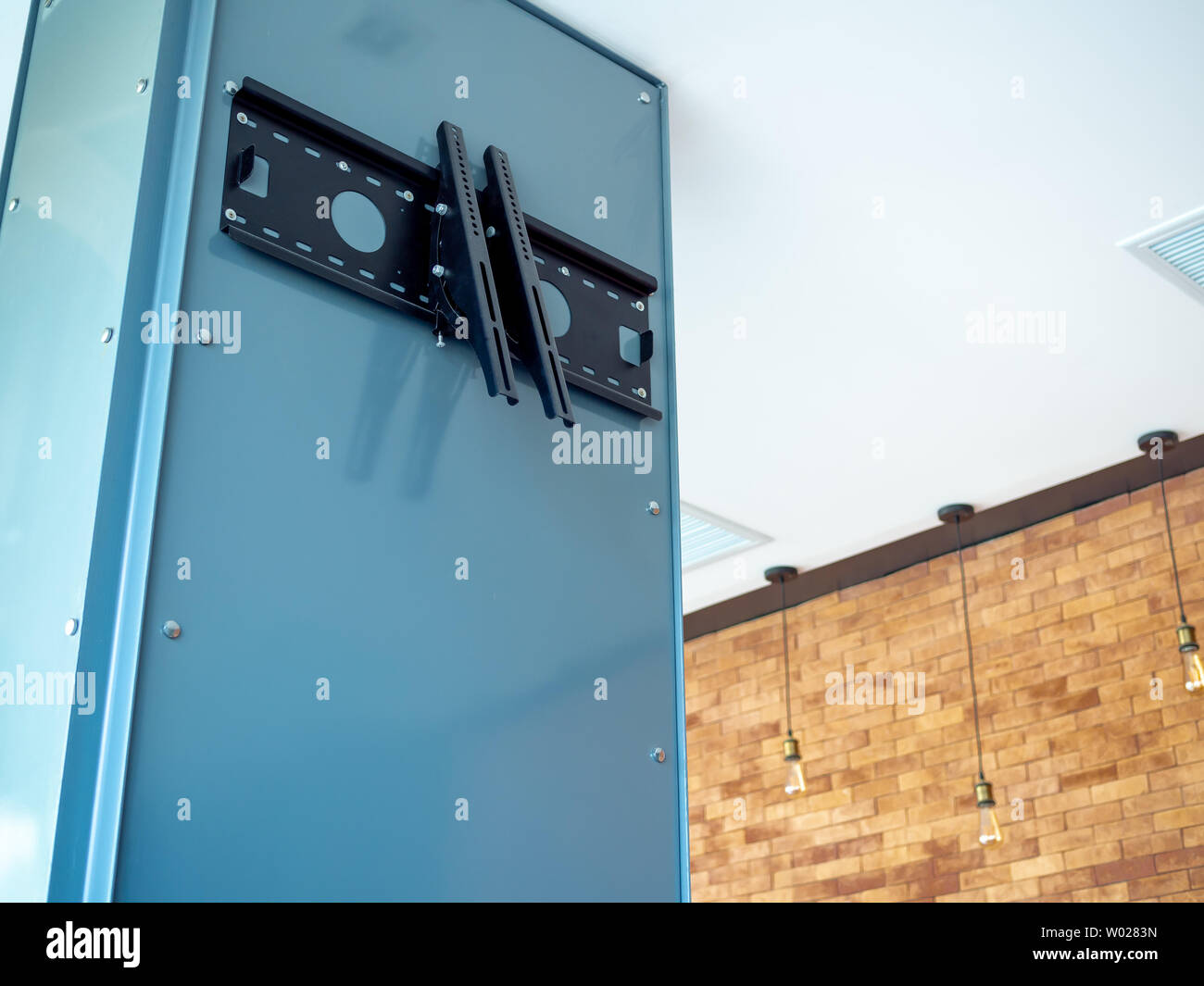 Black TV wall mount on blue steel pillar. TV hanger on the wall Stock ...