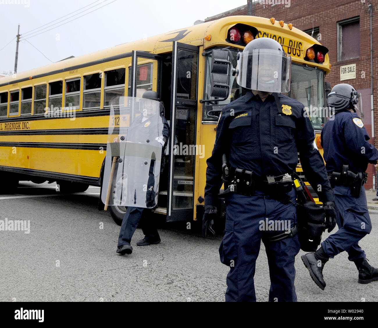 Policemen in riot gear exits a school bus to disperse the remaining ...