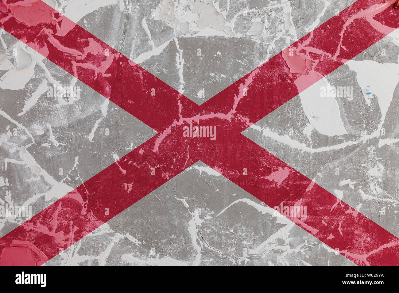 The national flag of the US state Alabama against a gray wall with ...