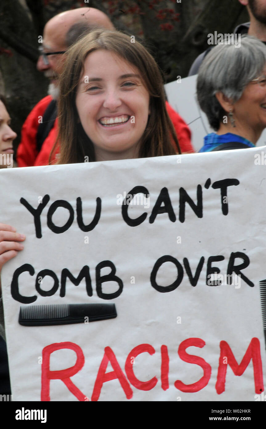 Anti-Trump demonstrators holds up their signs as the march to the rally ...