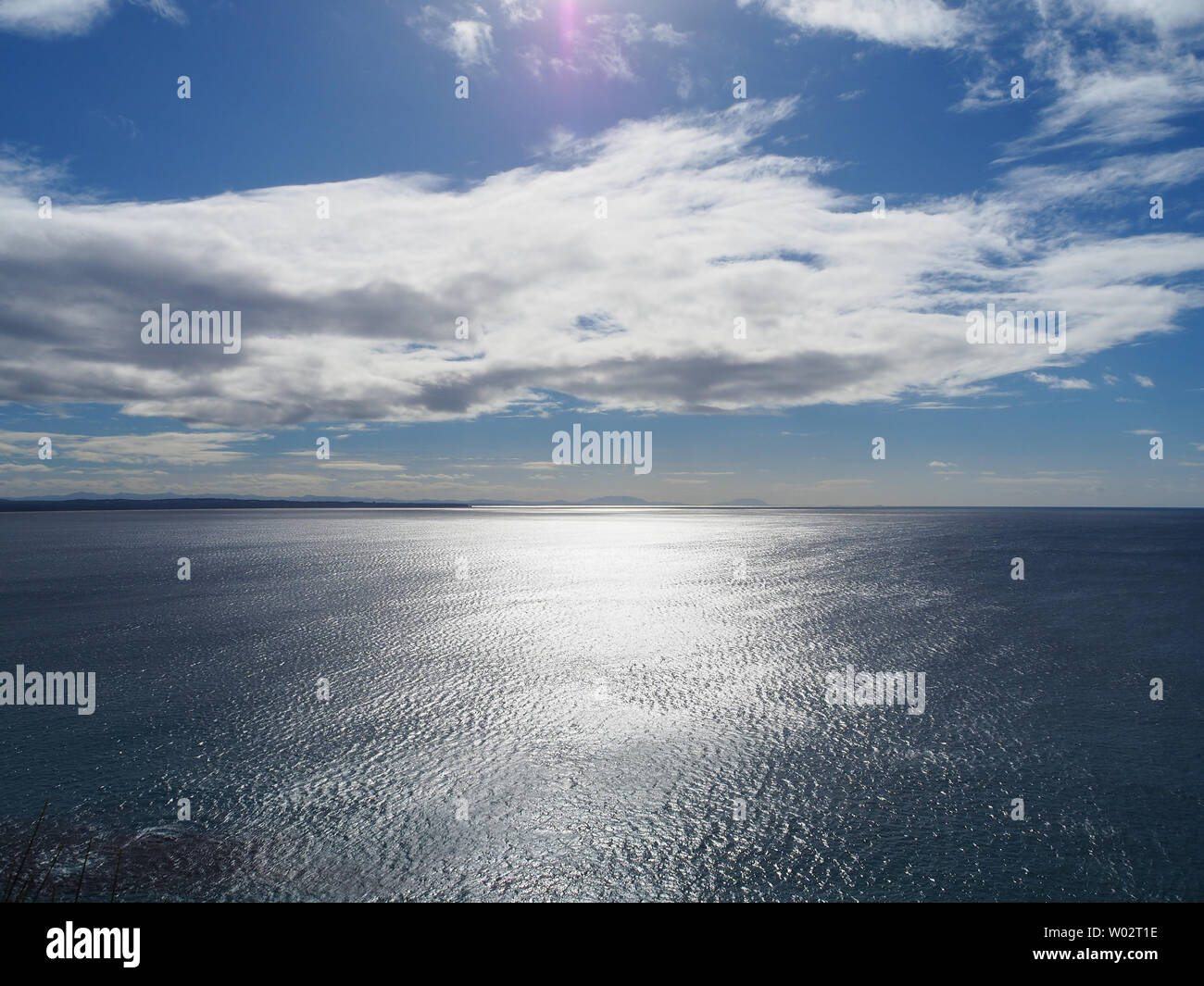 Flat sea mirroring clouds Stock Photo - Alamy