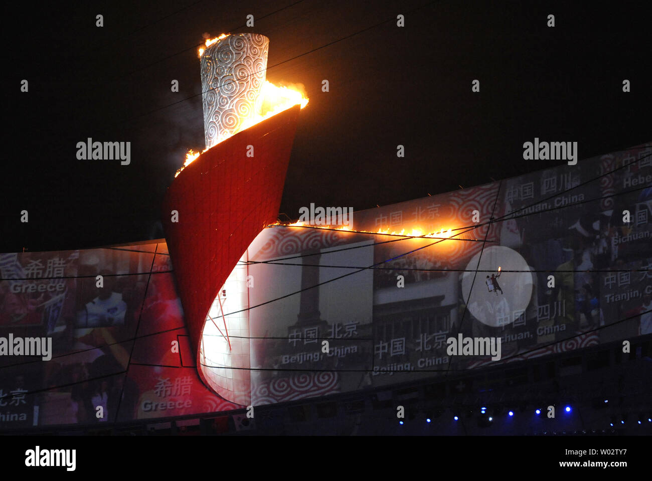 Chinese Gold Medalist Li Ning (R) lights the Olympic Cauldron atop at ...