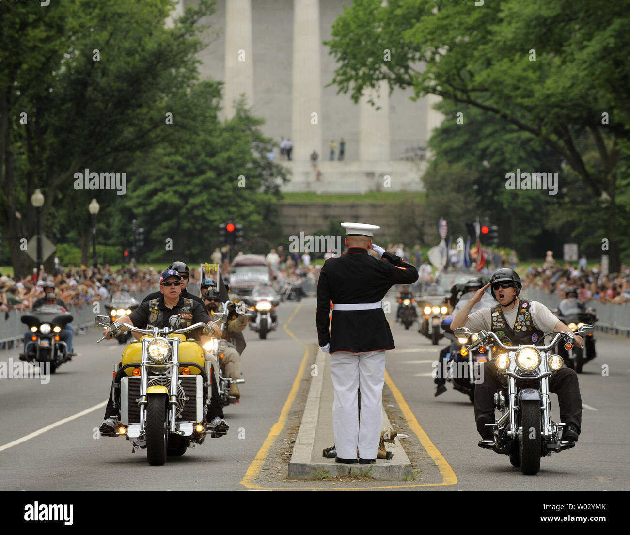 Bikers salute USMC SSgt. Tim Chambers who stands in the middle of the street as motorcycles roar ...