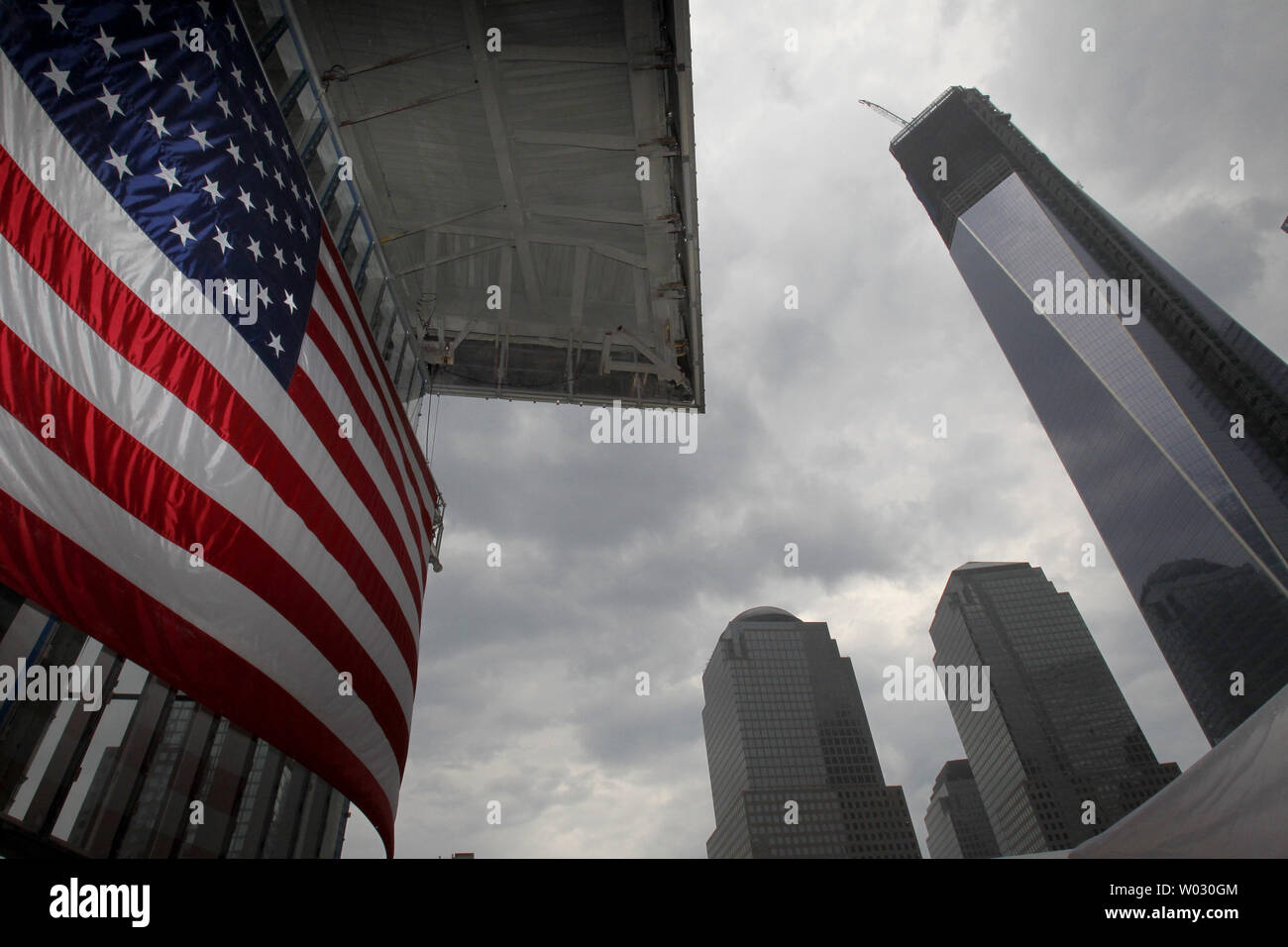 One world Trade center stands to the right of a flag that hangs on 4 ...