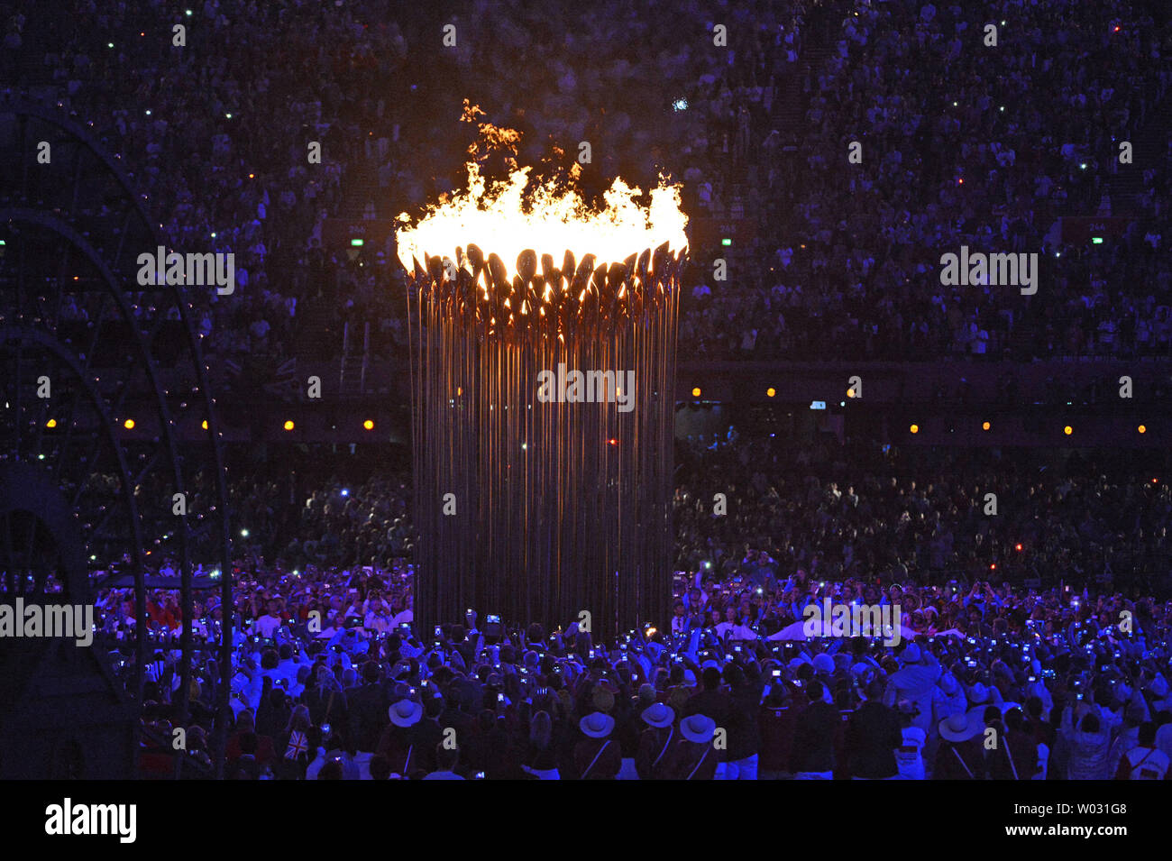 The Olympic flame lights the cauldron at the Stadium during the opening ...