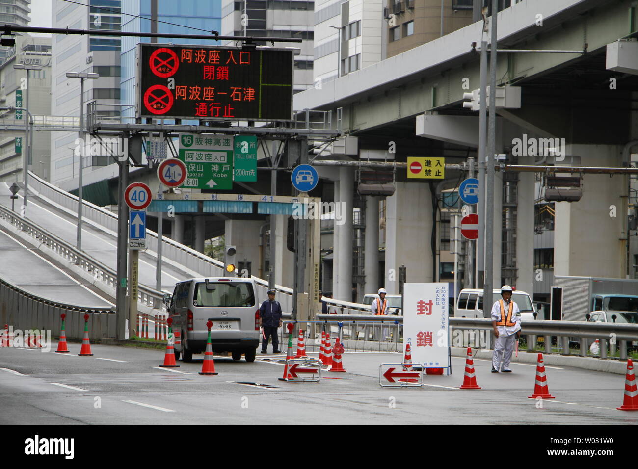 A police officer controls traffic near the expressway in central Osaka ...