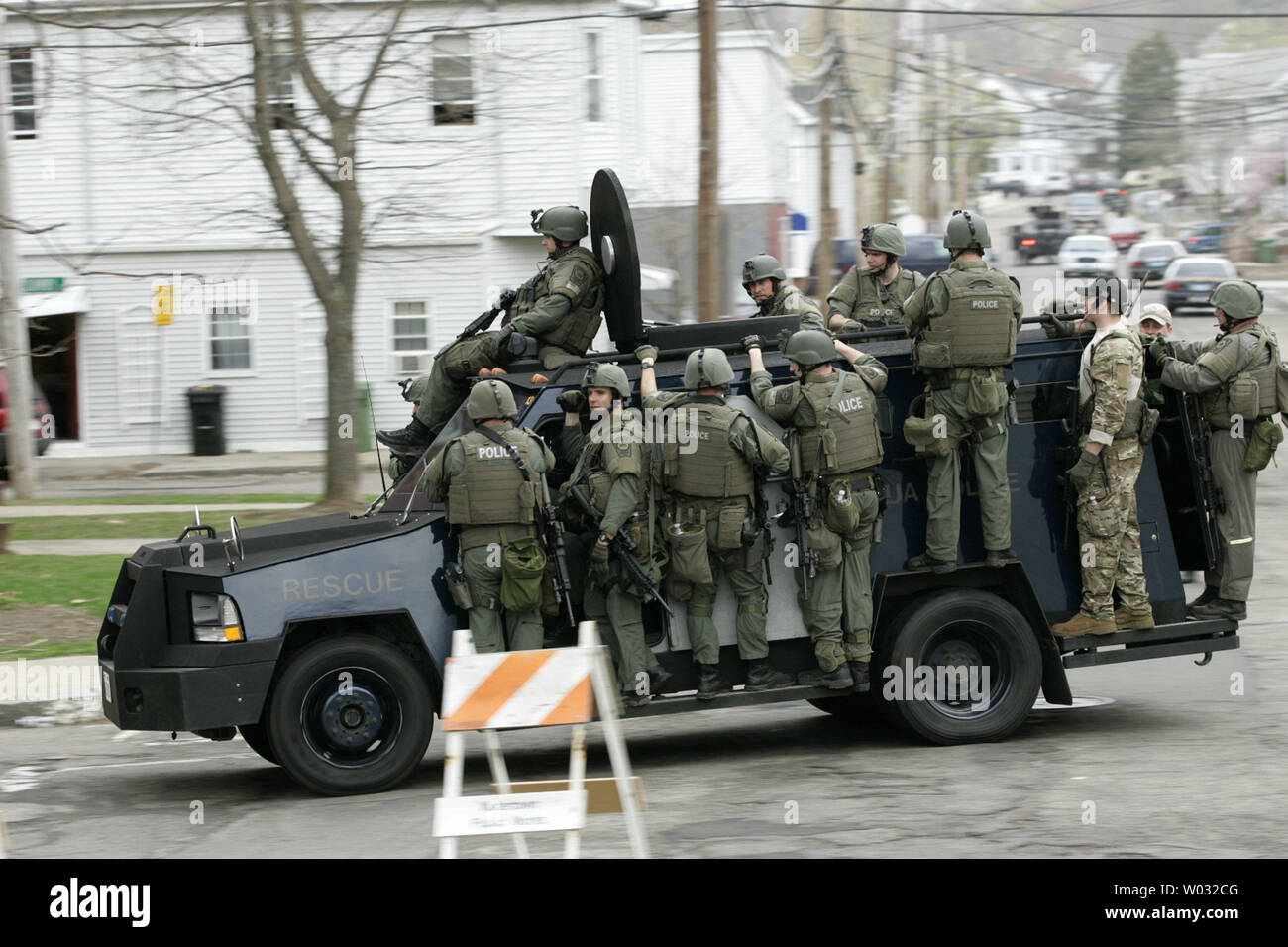 SWAT team members are driven down Melendy Avenue on the back of an ...