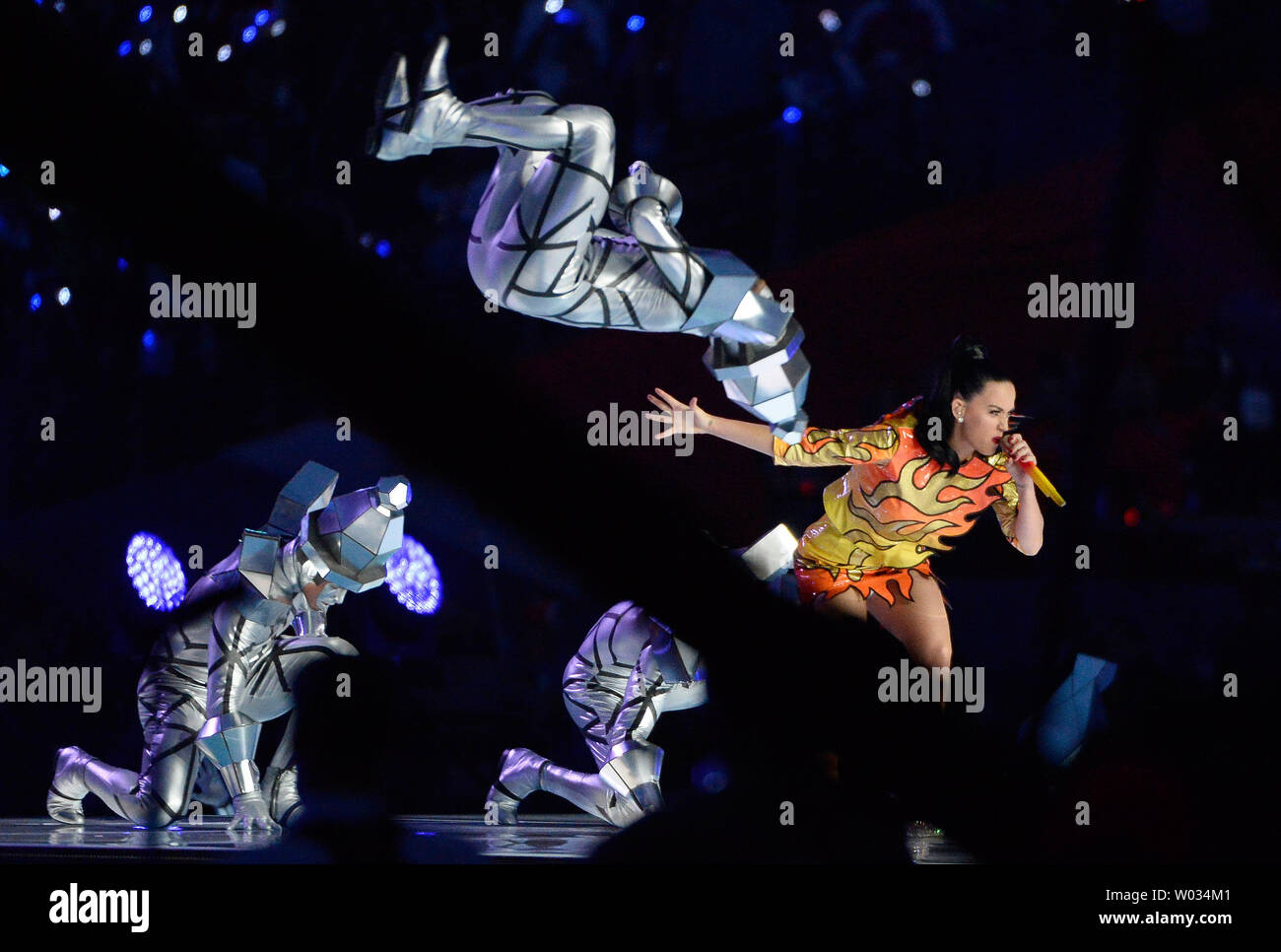 Performers flip in the background as Katy Perry sings during halftime ...