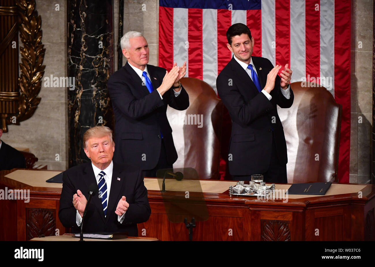 President Donald Trump, backed by Vice President Mike Pence (L) and ...