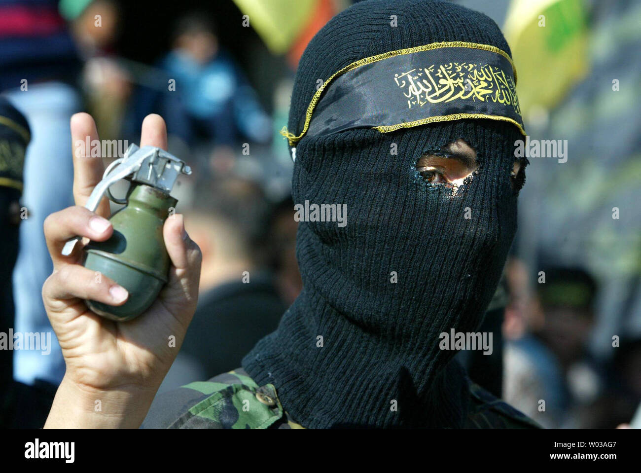 A Palestinian Hamas militant hold up hand grenades as they parade in ...