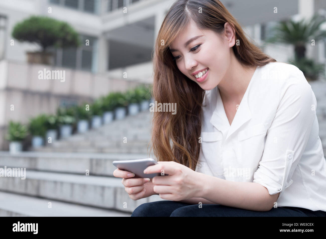 Asian beautiful female student using mobile phone in campus Stock Photo ...