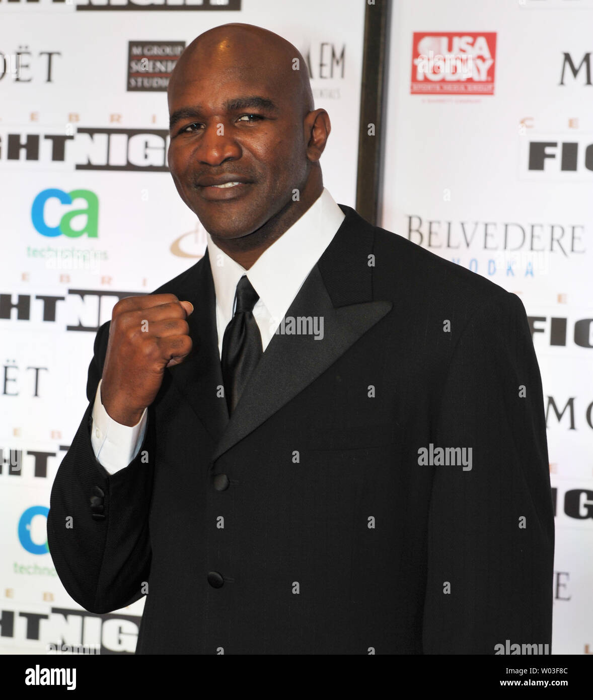 Evander Holyfield shows his fist as he walks the red carpet at the ...