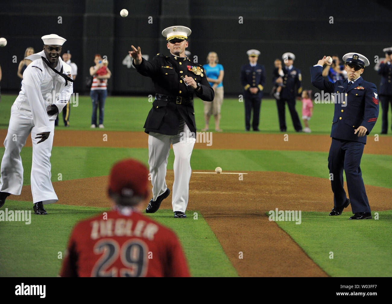 Members of the military throw out the ceremonial first pitch before the ...