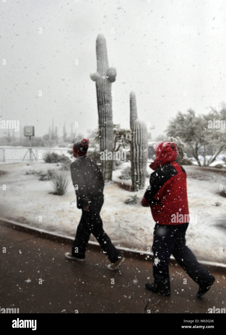 Fans walk in the snow that suspended the first round of the Accenture ...