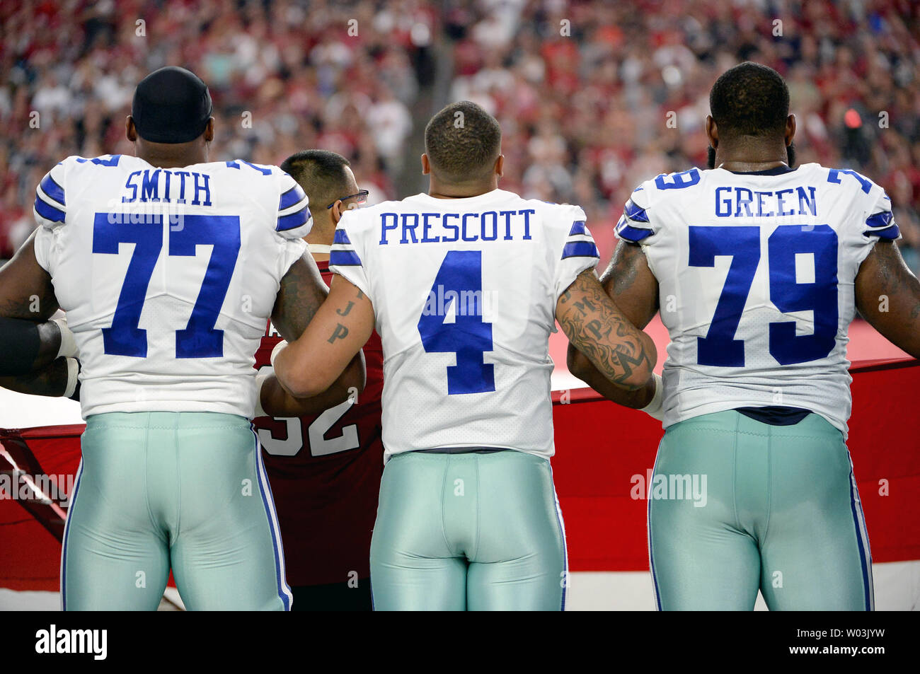 Dallas Cowboys' Tyron Smith (L), Dak Prescott and Chaz Green lock arms ...