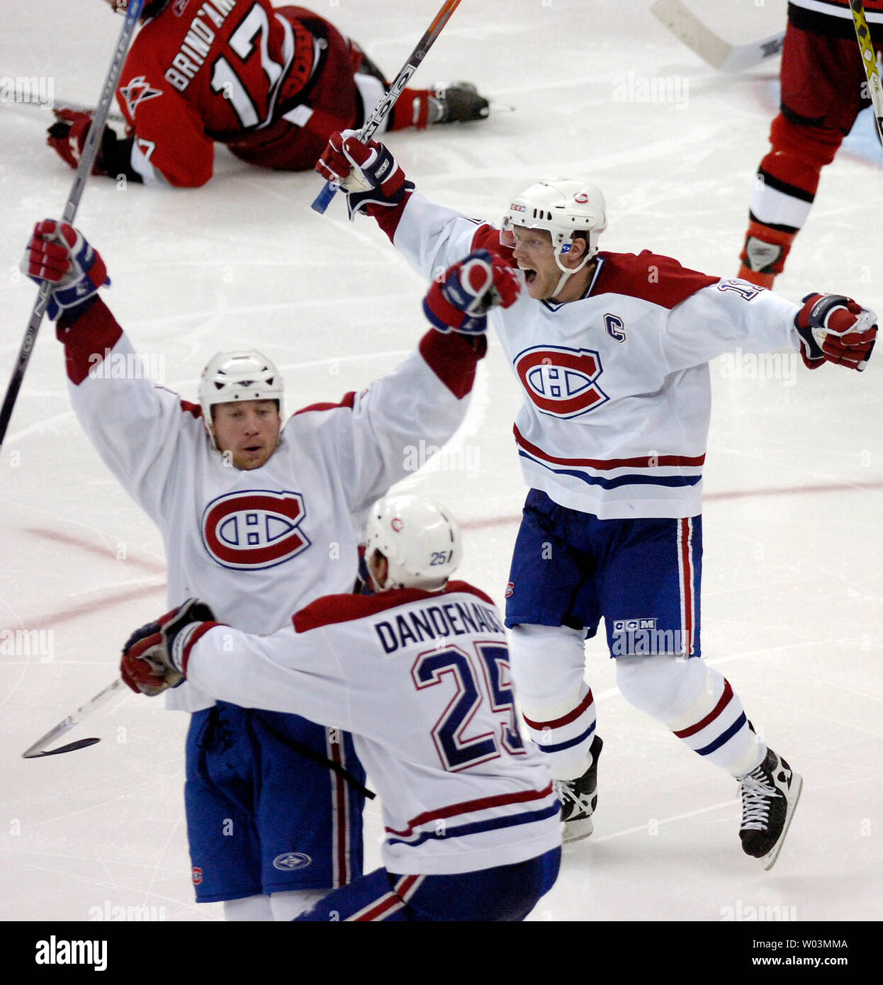 Montreal Canadiens' Mathieu Dandenault, bottom, skates toward teammate ...
