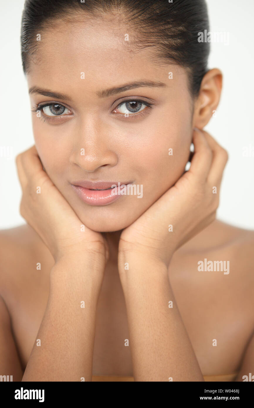 Portrait of a woman touching her cheeks Stock Photo - Alamy