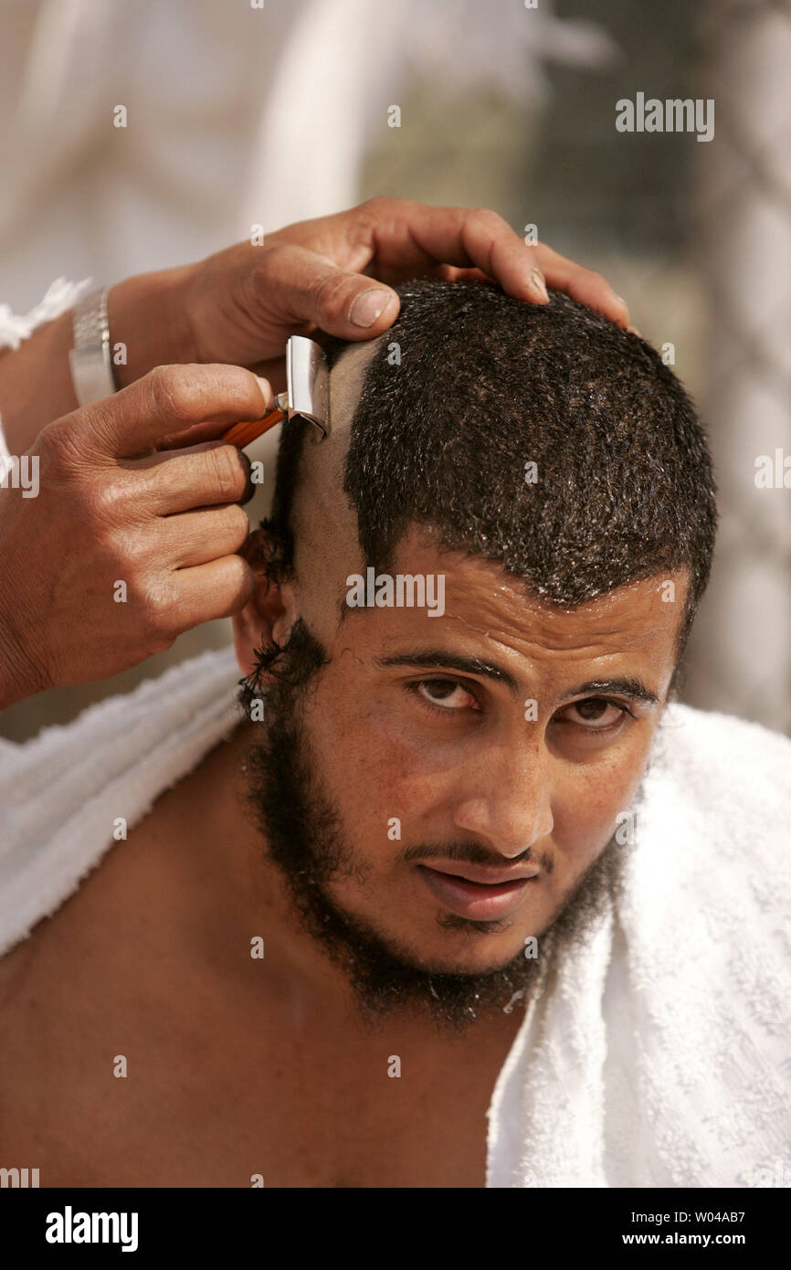 A pilgrim's head is shaved as part of the Hajj tradition, in the Mina ...