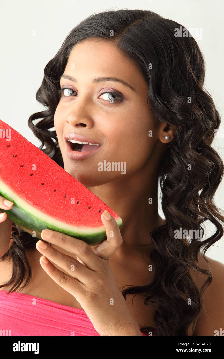Portrait of a woman eating watermelon Stock Photo - Alamy