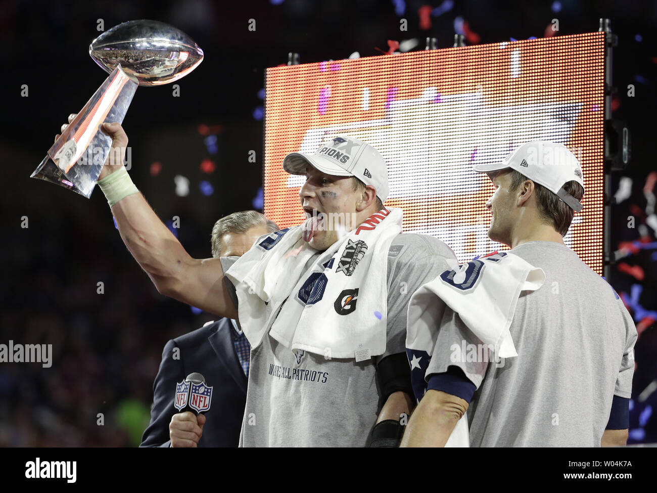 New England Patriots tight end Rob Gronkowski (L) holds the Lombardi trophy alongside of ...