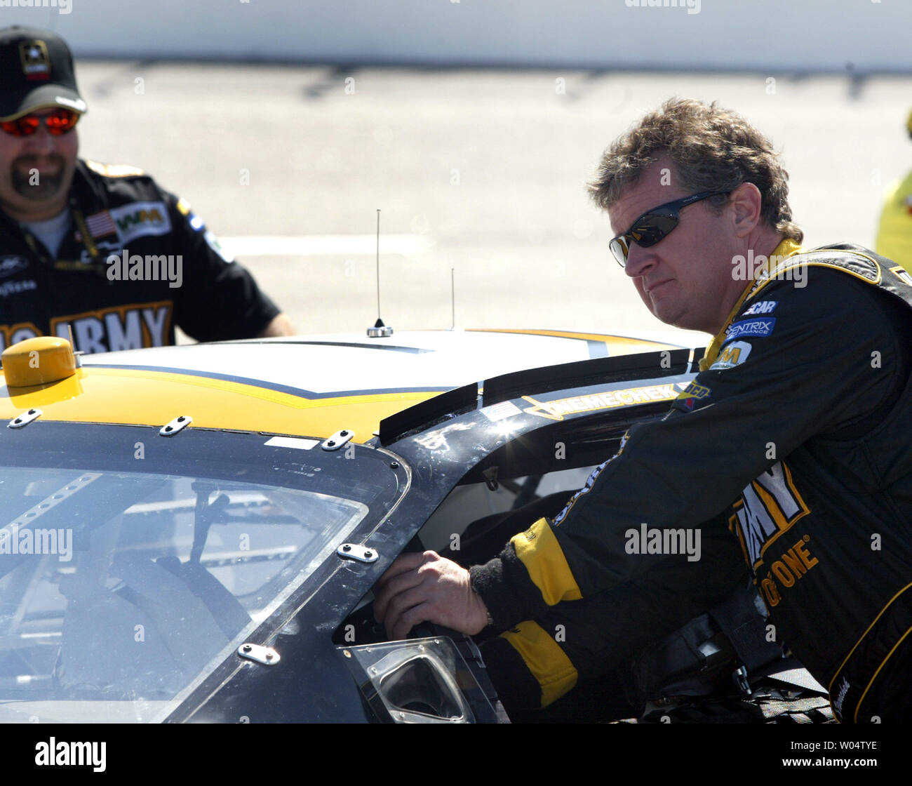 Race car driver Joe Nemechek pushes his race car as he waits his turn ...