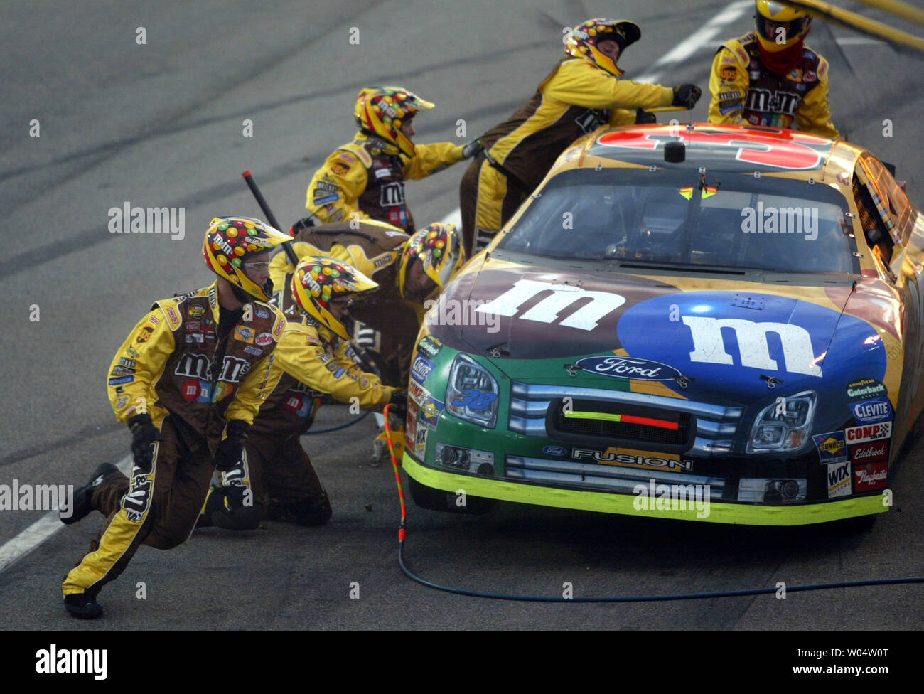 The M&M's Ford pit crew works on Elliott Sadler's car on pit road ...