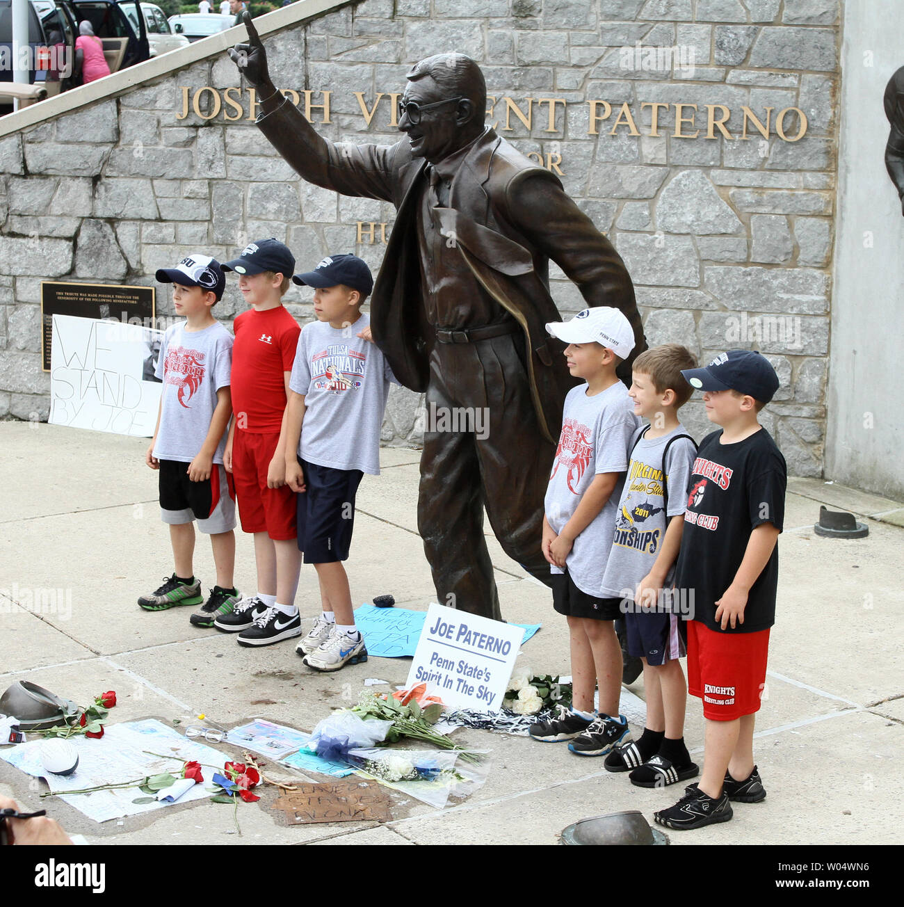 Children pose with the Joe Paterno statue outside Beaver Stadium in ...