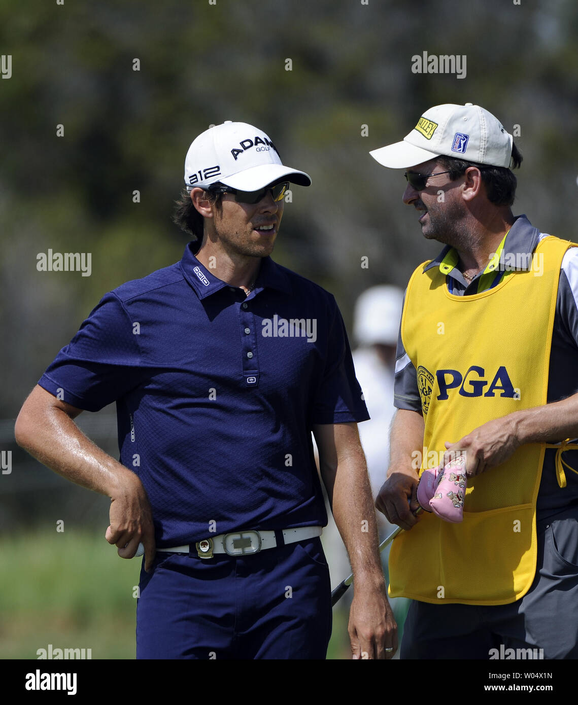 Aaron Baddeley of Australia talks to his caddie on hole four during the ...