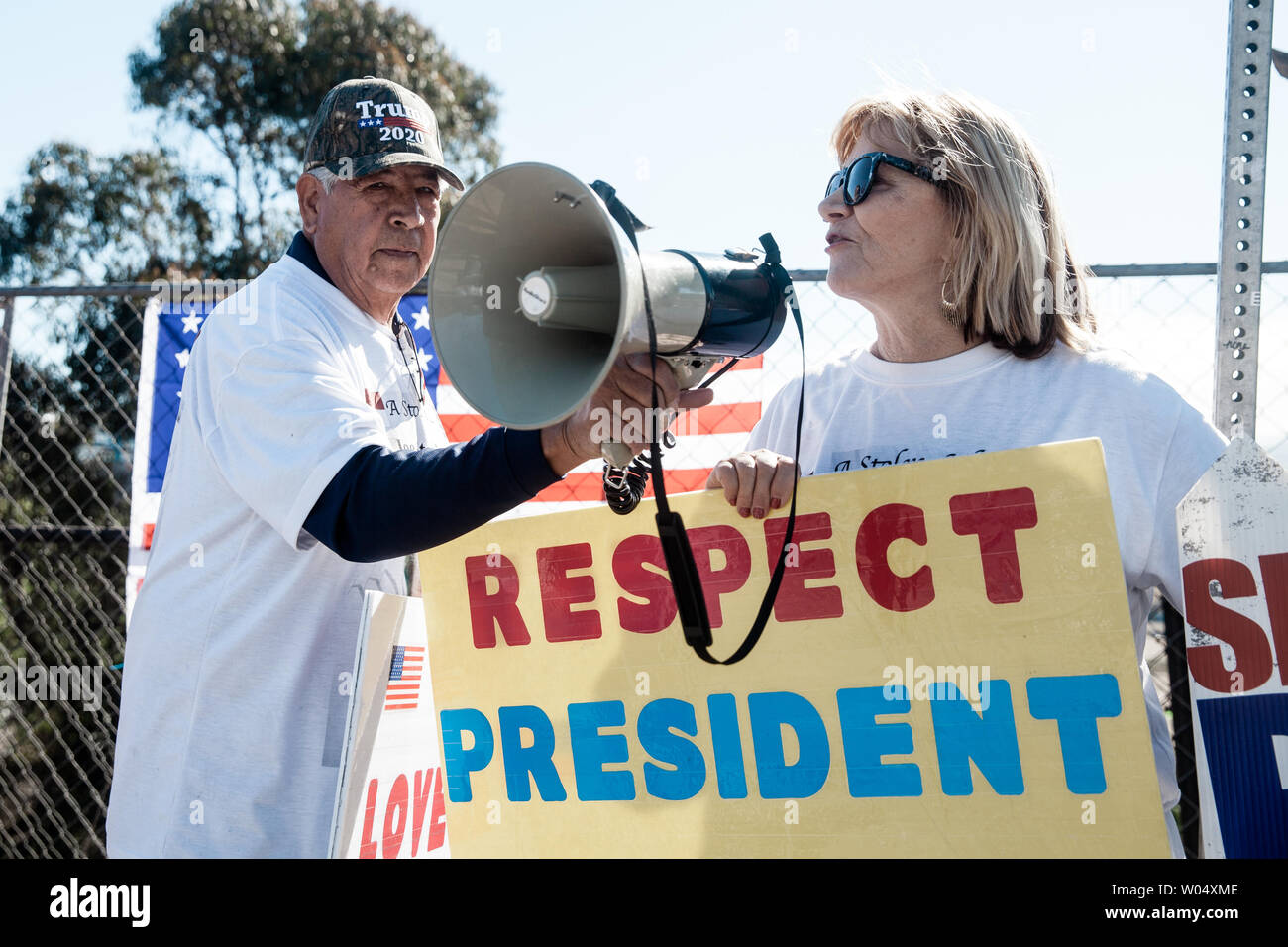 Demonstrators hold signs at an "America First" rally at the San Ysidro ...