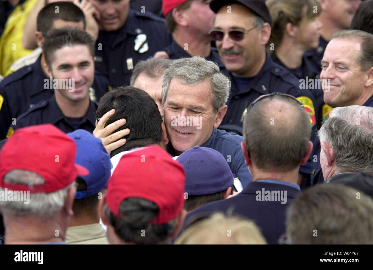U.S. President George W. Bush hugs a fireman on his arrival to speak to ...
