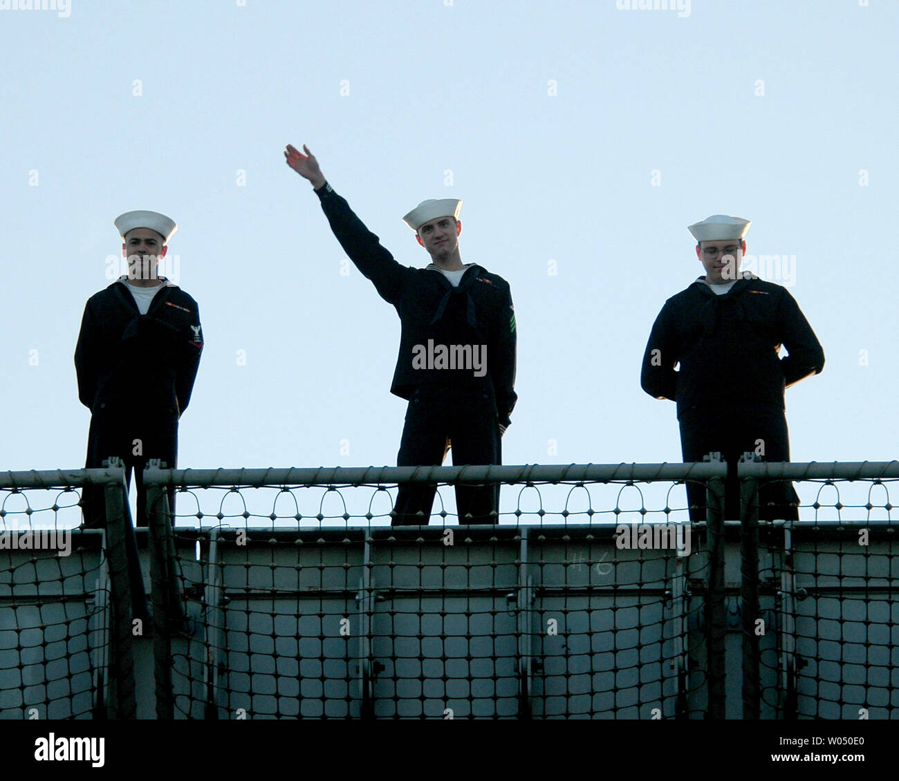 U.S. Navy sailor Billy Skinner, center, waves to his girlfriend as he ...