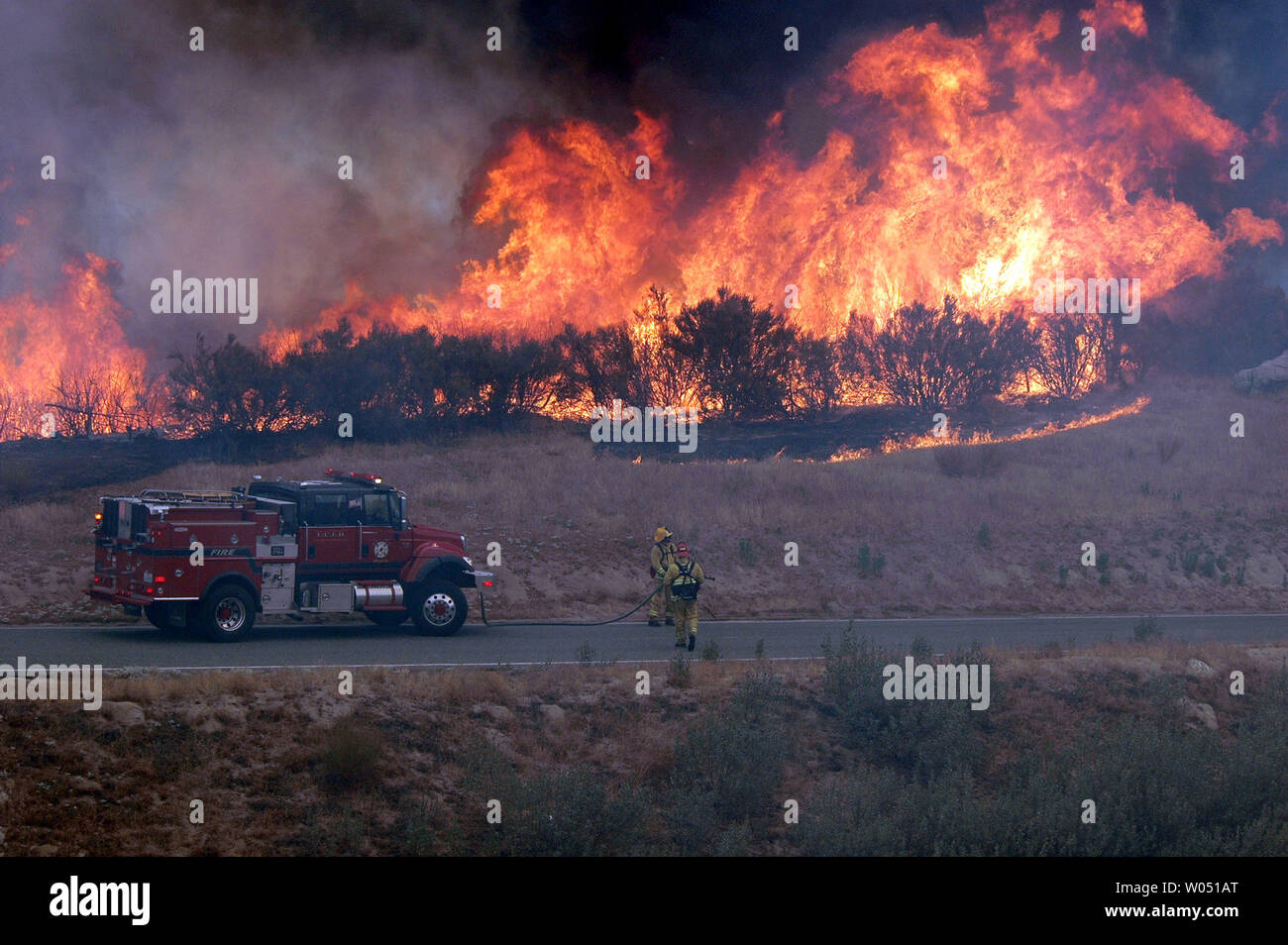 Firefighters watch over a fast moving wildfire 40 miles east of San ...