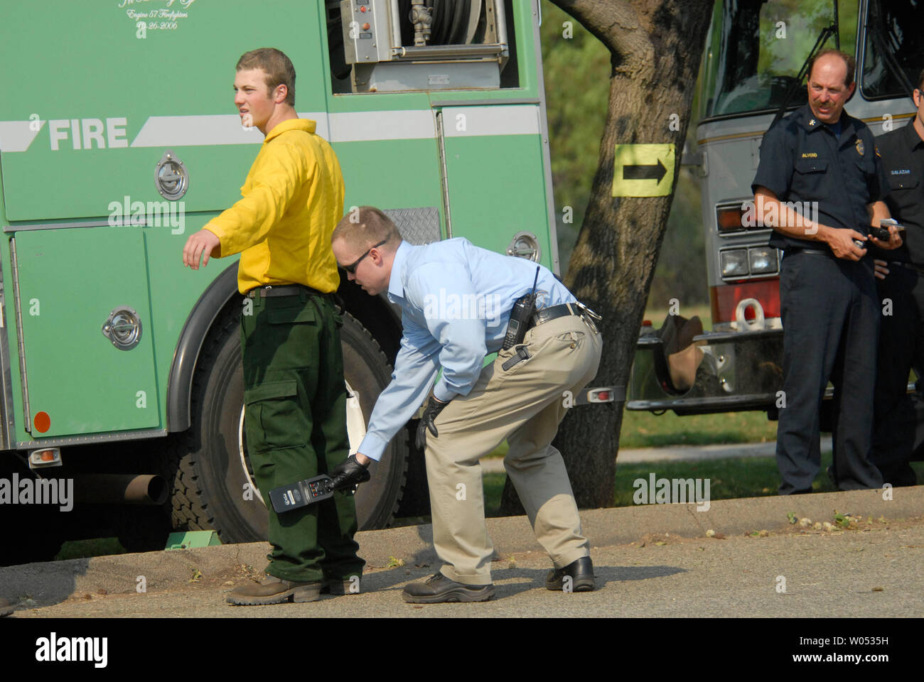A Secret Service Agent runs a metal detector over firefighters before ...