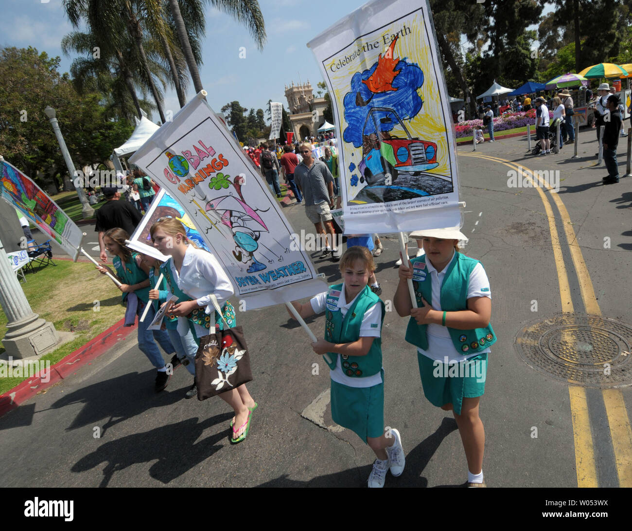 A group of Girl Scouts Carrie banners during a celebration of Earth Day ...