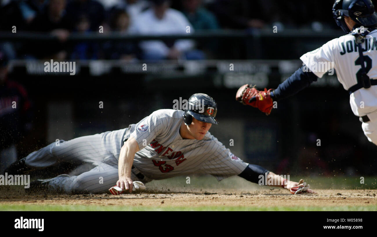 Minnesota Twins' Justin Morneau, left, slides past the attempted tag of ...