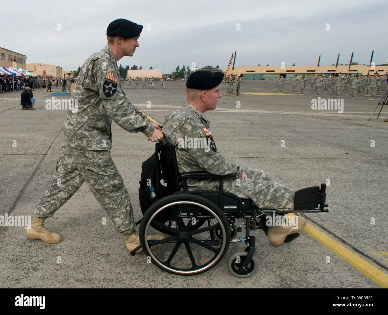 Capt. Dave Rogers (L) pushes Capt. A.J. Tong, (R) as he joins his unit ...