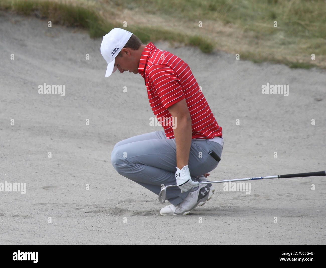 Jordan Spieth reacts to a poor shout out of the sand on the ninth hole ...