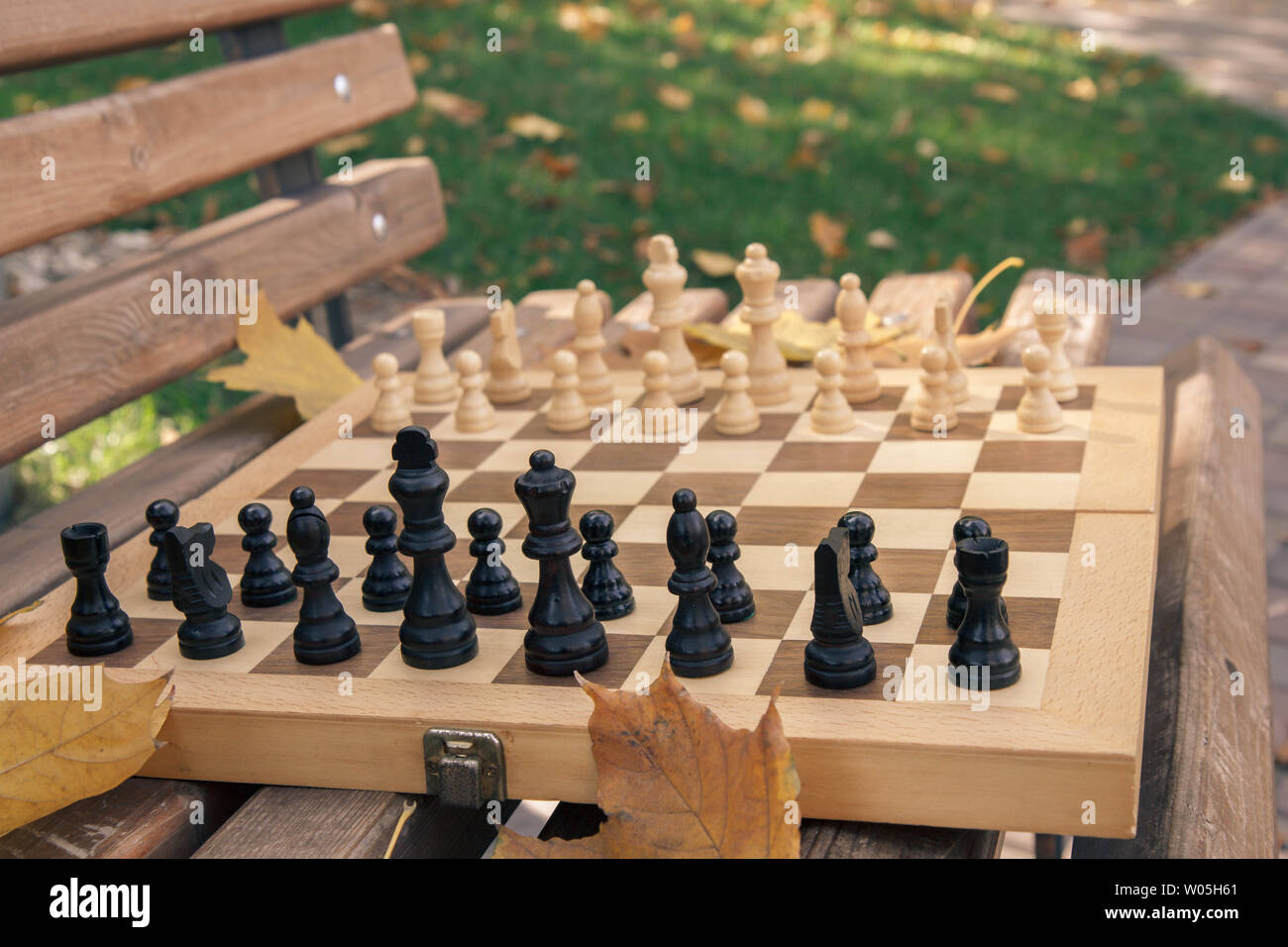 Wooden chess on the bench in a city park. Shallow depth of field. Focus ...