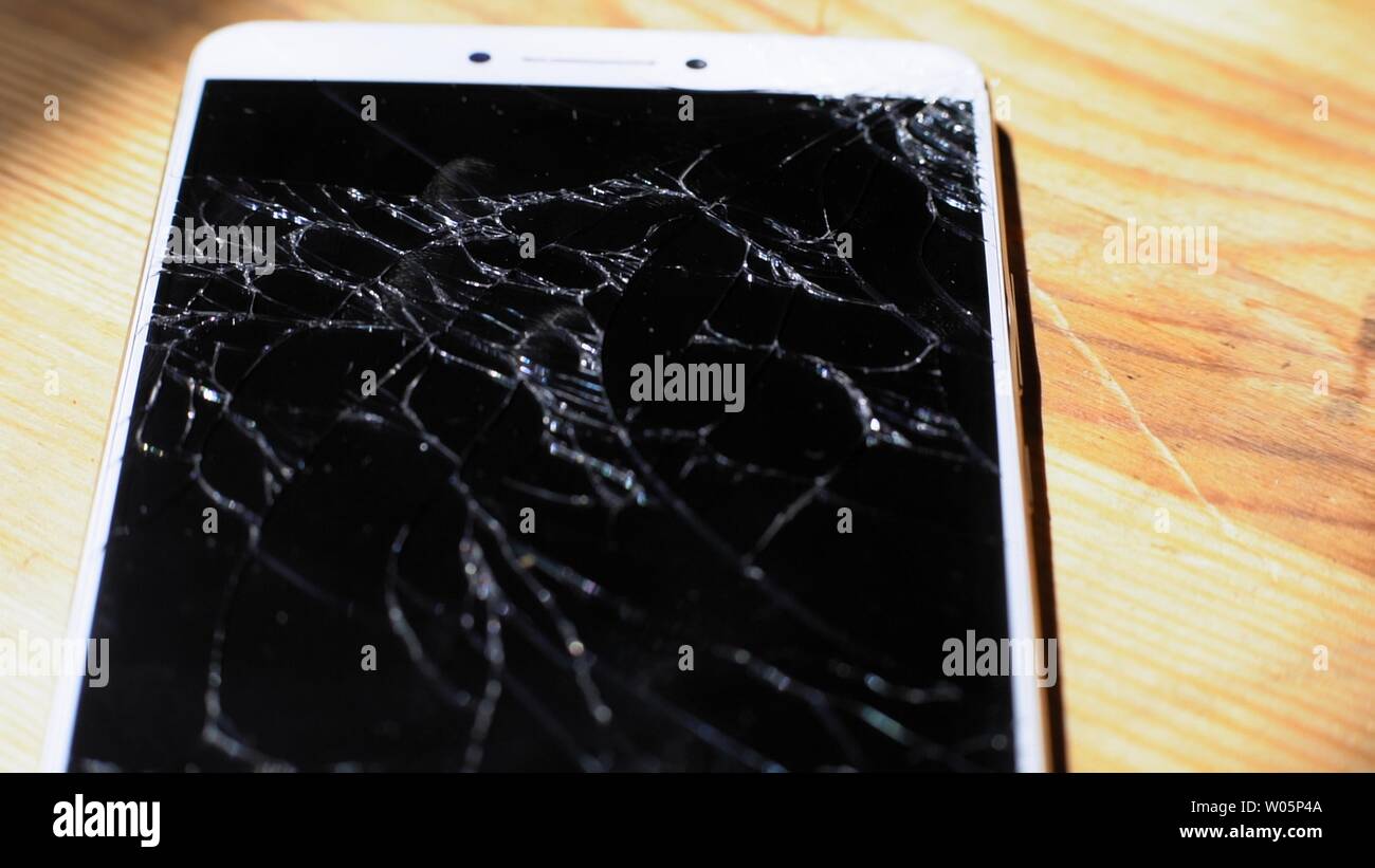 Xiaomi MI Max smartphone with broken screen matrix lies on wooden table ...