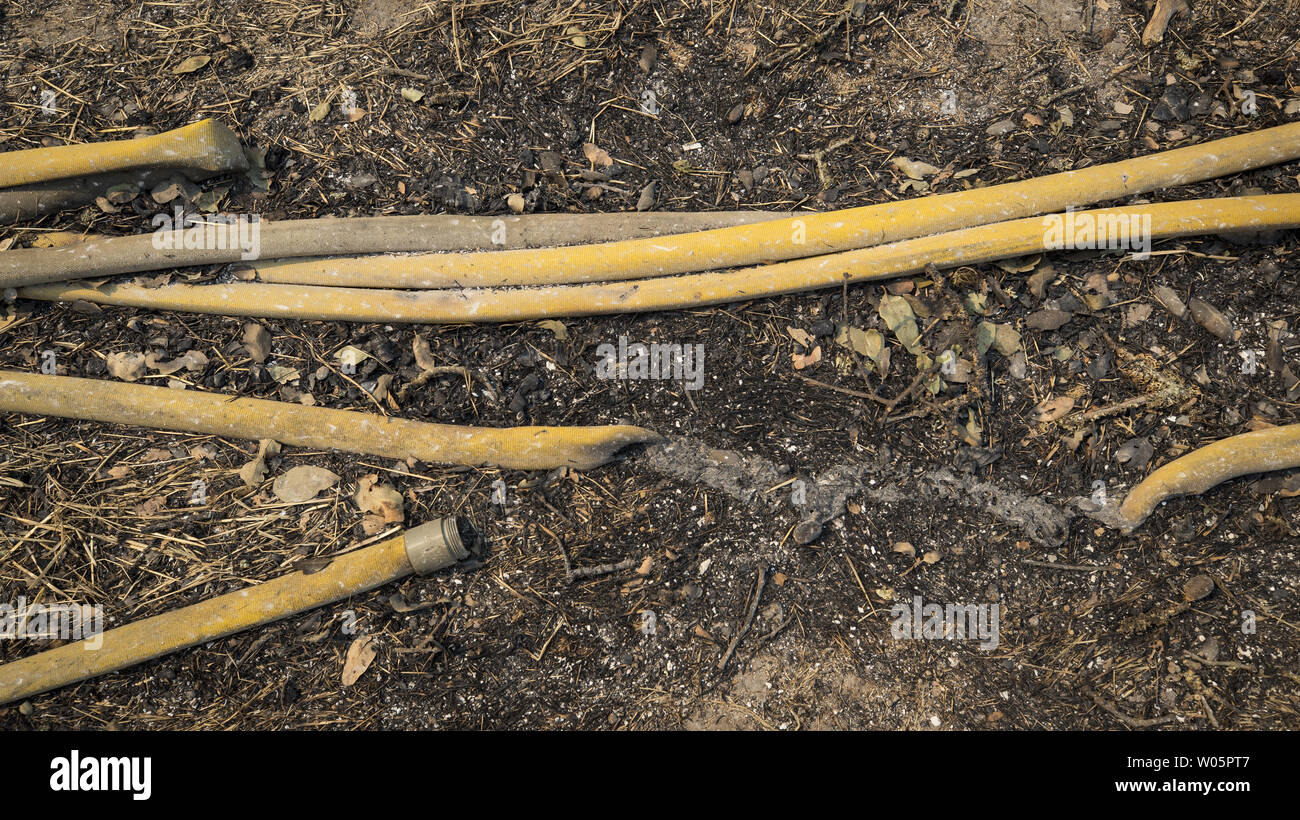 Melted fire hose sits alongside a charred house after a failed bid to ...
