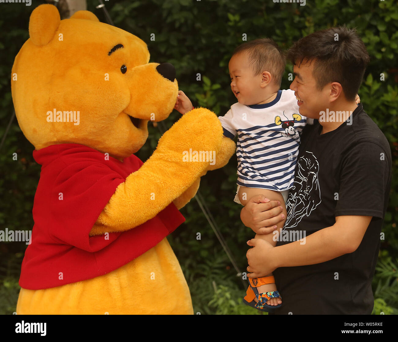 A Chinese young boy meets a Winnie the Pooh mascot in Shanghai ...