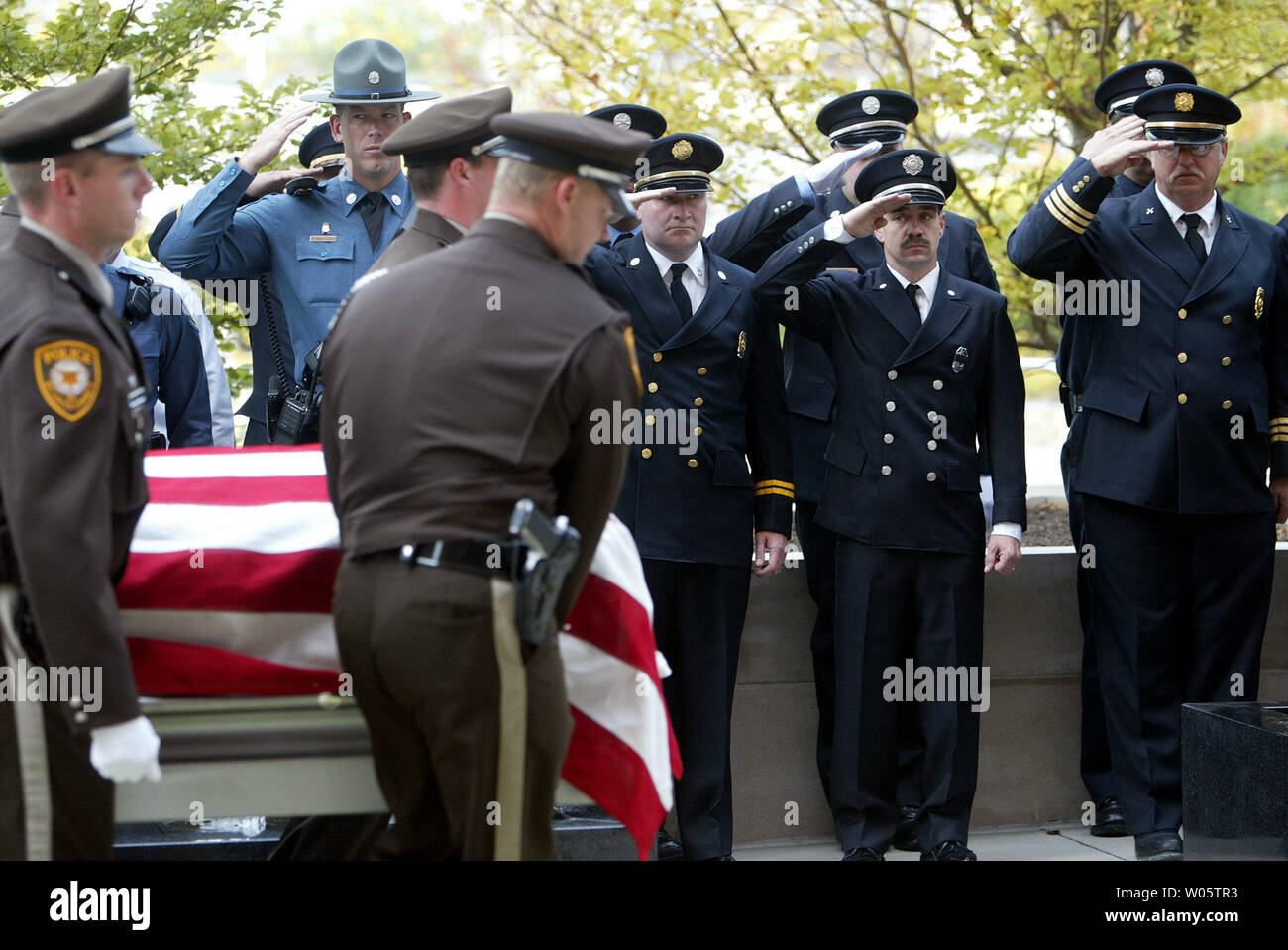 Police officers salute the casket of the late St. Louis County ...