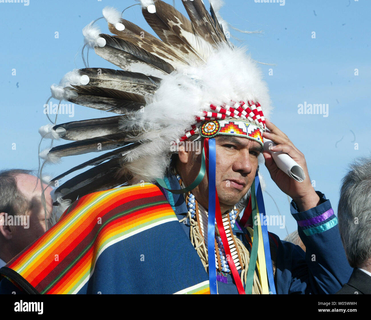 Tex Hall, (Red Tipped Arrow) holds onto his head dress as a stiff wind ...