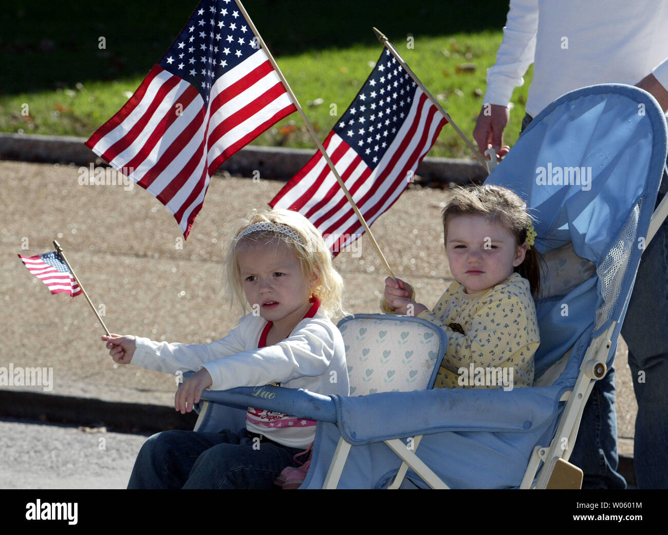 Brailey White (R) 2 and Brianna Eckrich, 3, wave their flags as they ...