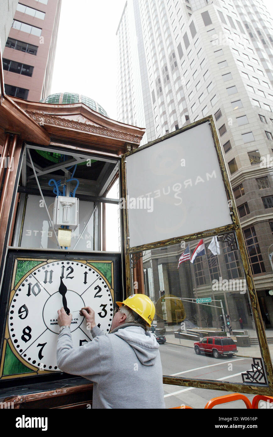 Charles Hellige of St. Louis Time & Signal places the hands on a large ...