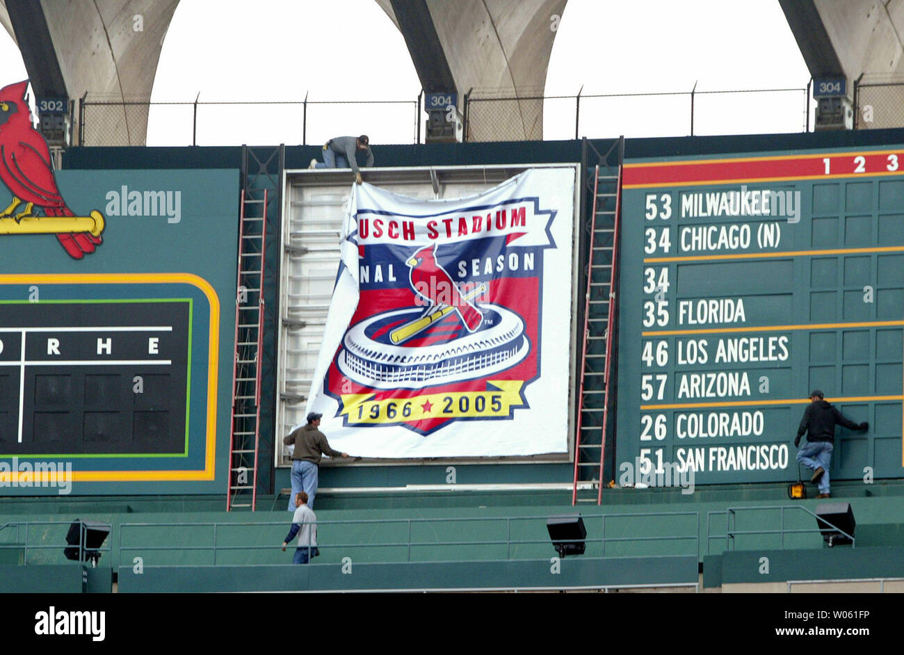 Workers install a new banner near the scoreboard in centerfield at ...