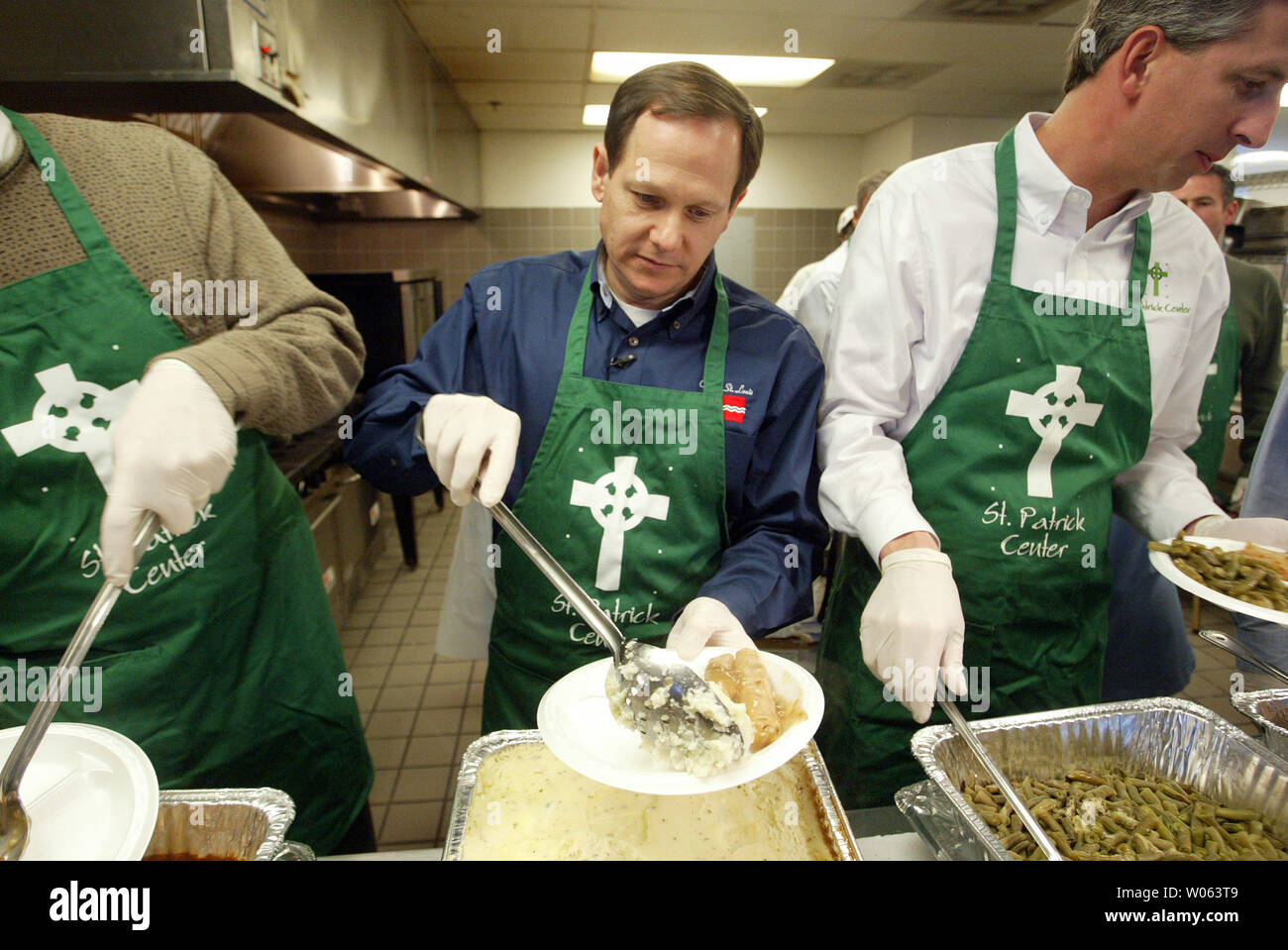 St. Louis Mayor Francis Slay places food on a plate as he helps out ...