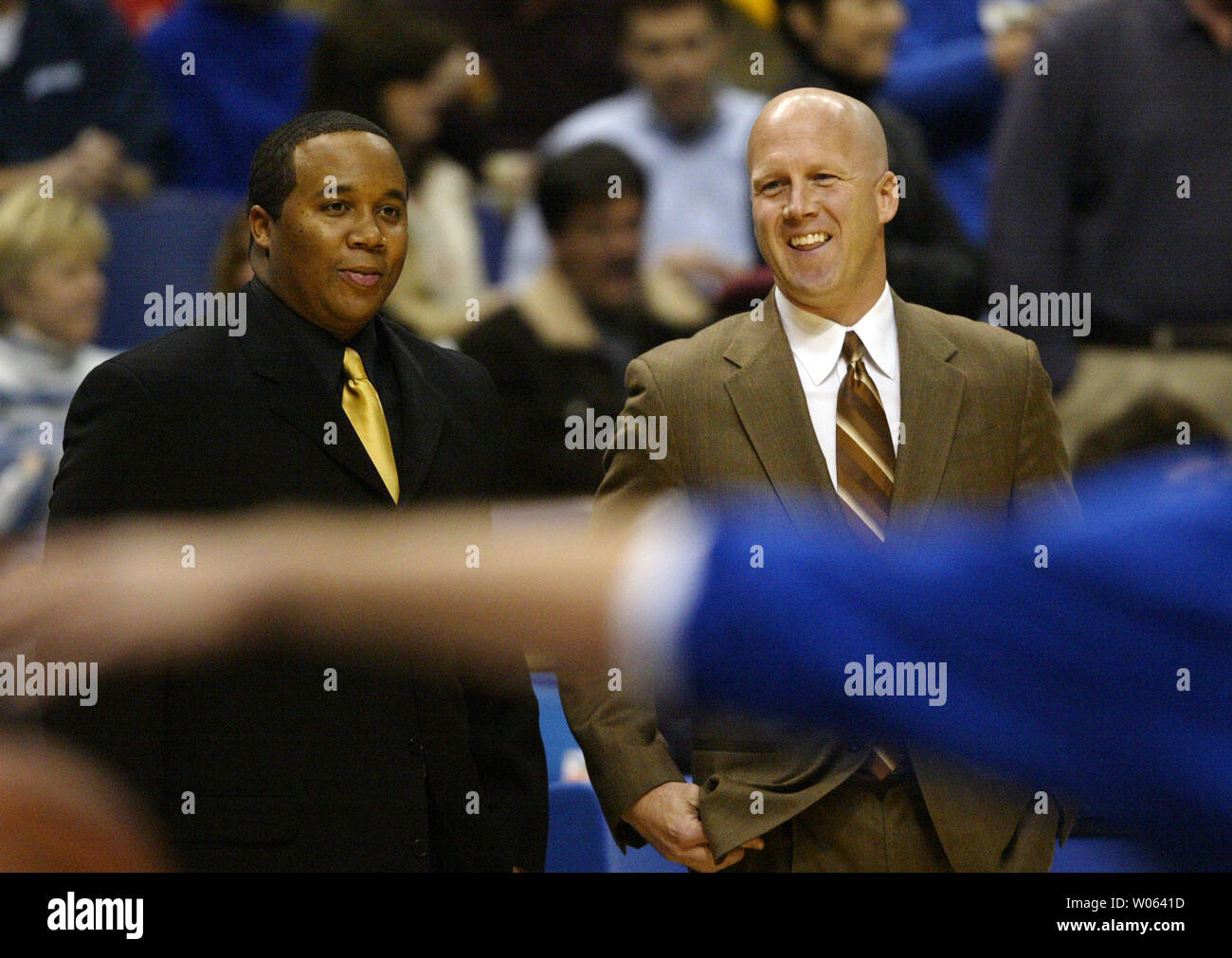 Saint Louis University's head basketball coach Brad Soderberg (R) jokes ...